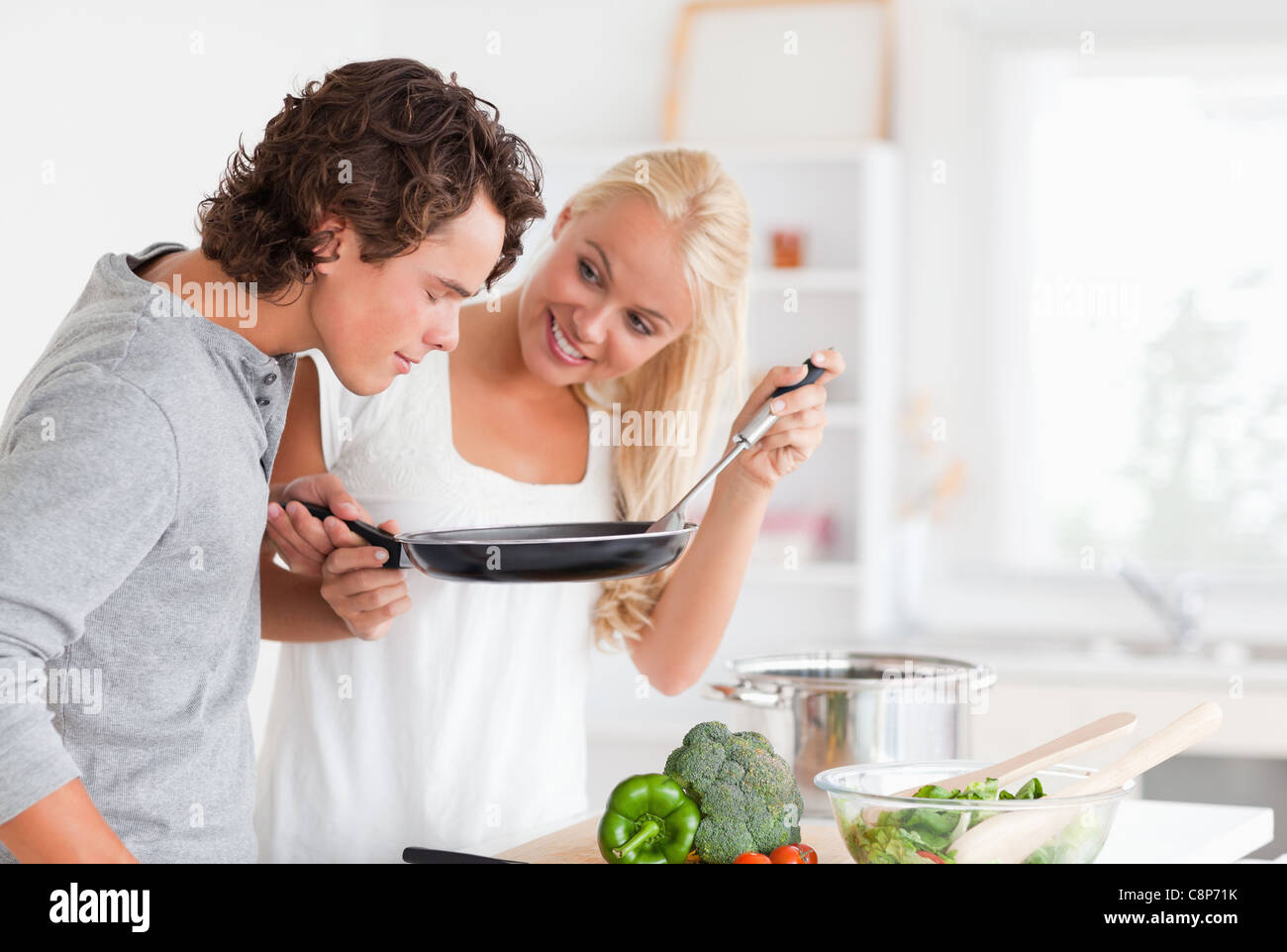 Couple cooking with a pan Stock Photo - Alamy