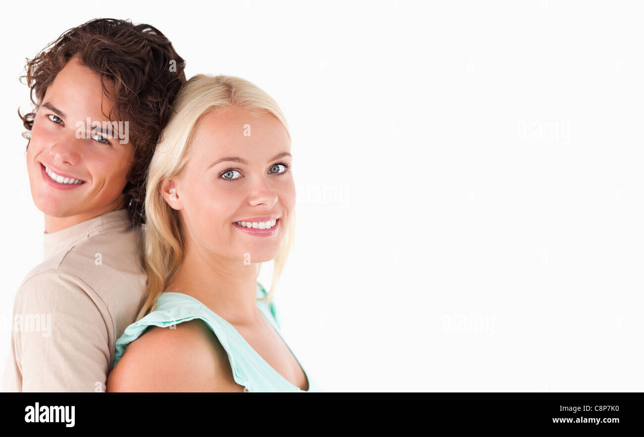 Portrait of a joyful couple standing back to back Stock Photo - Alamy