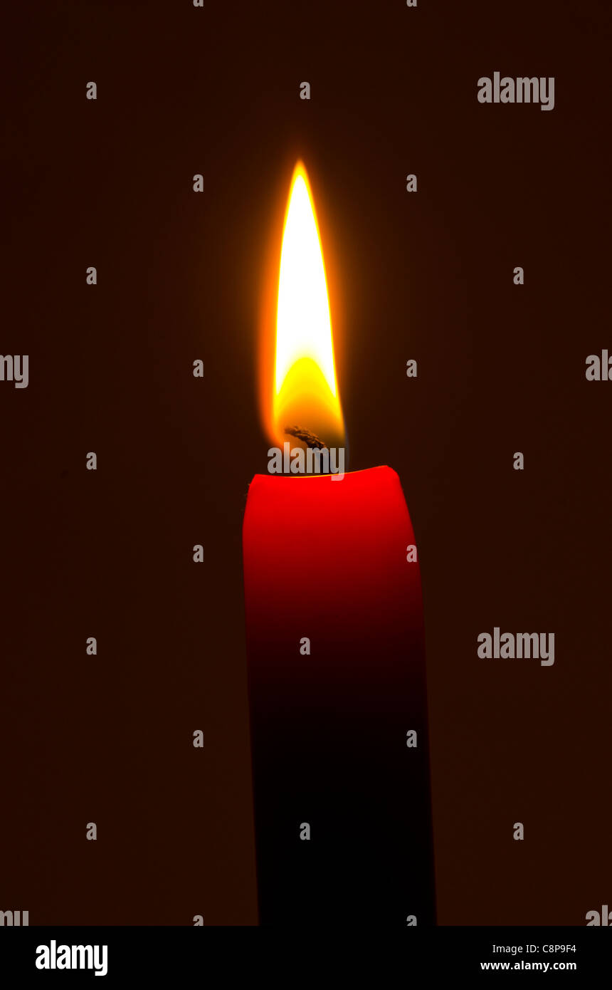 red candle flame and dark background Stock Photo - Alamy