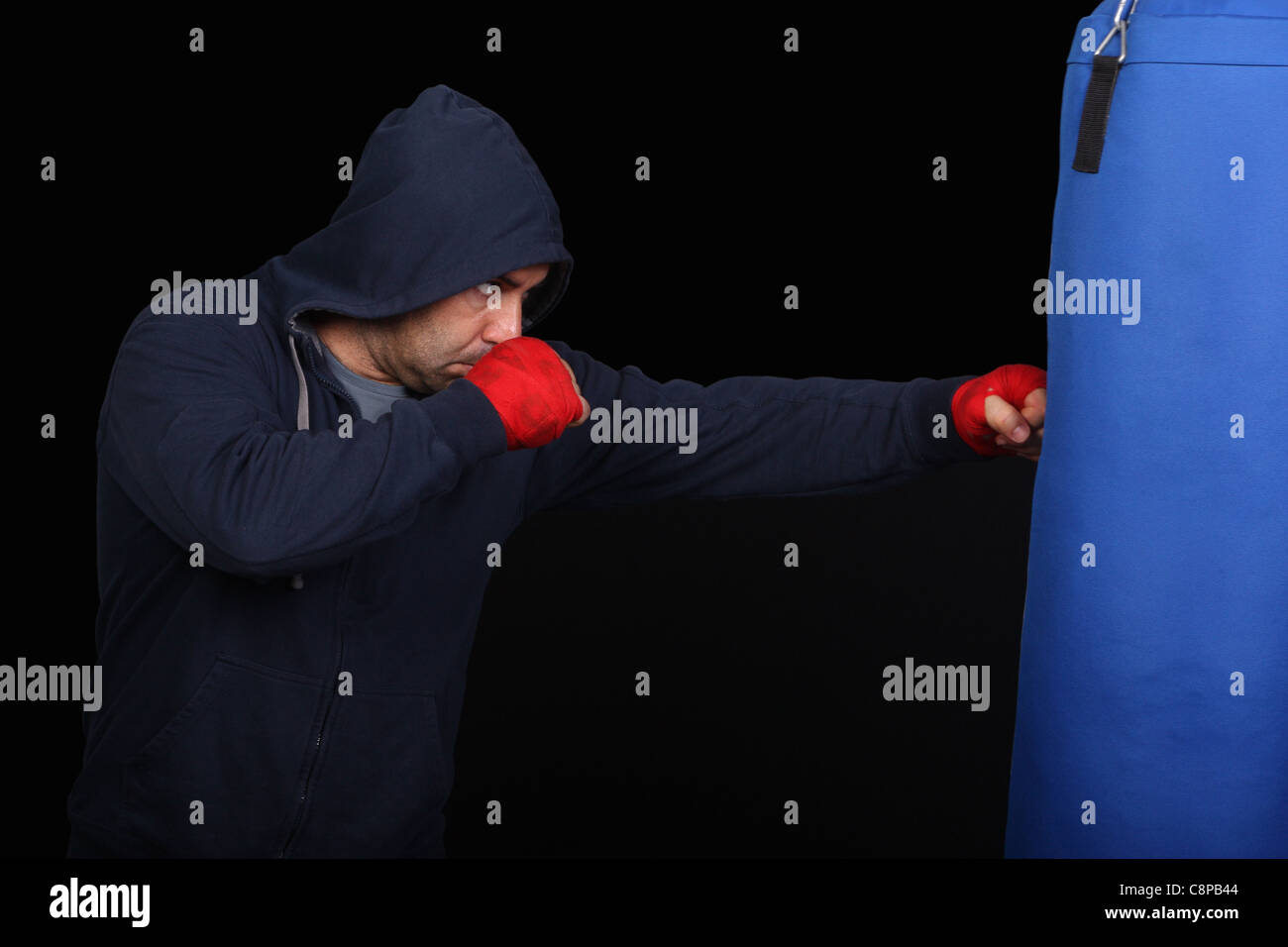 Fighter in training moment with a punching bag Stock Photo - Alamy