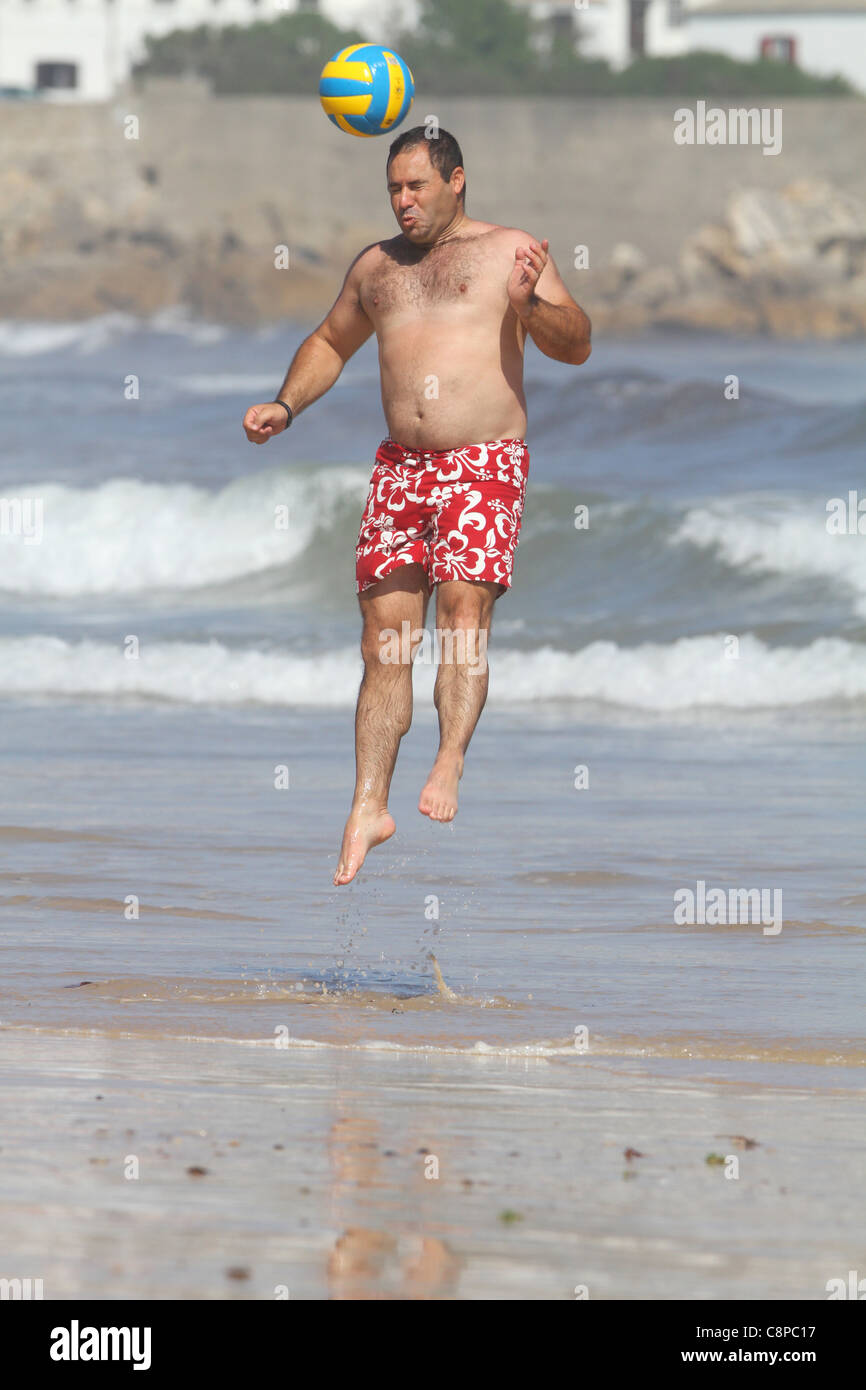 Fat man playing with a ball on the beach Stock Photo - Alamy