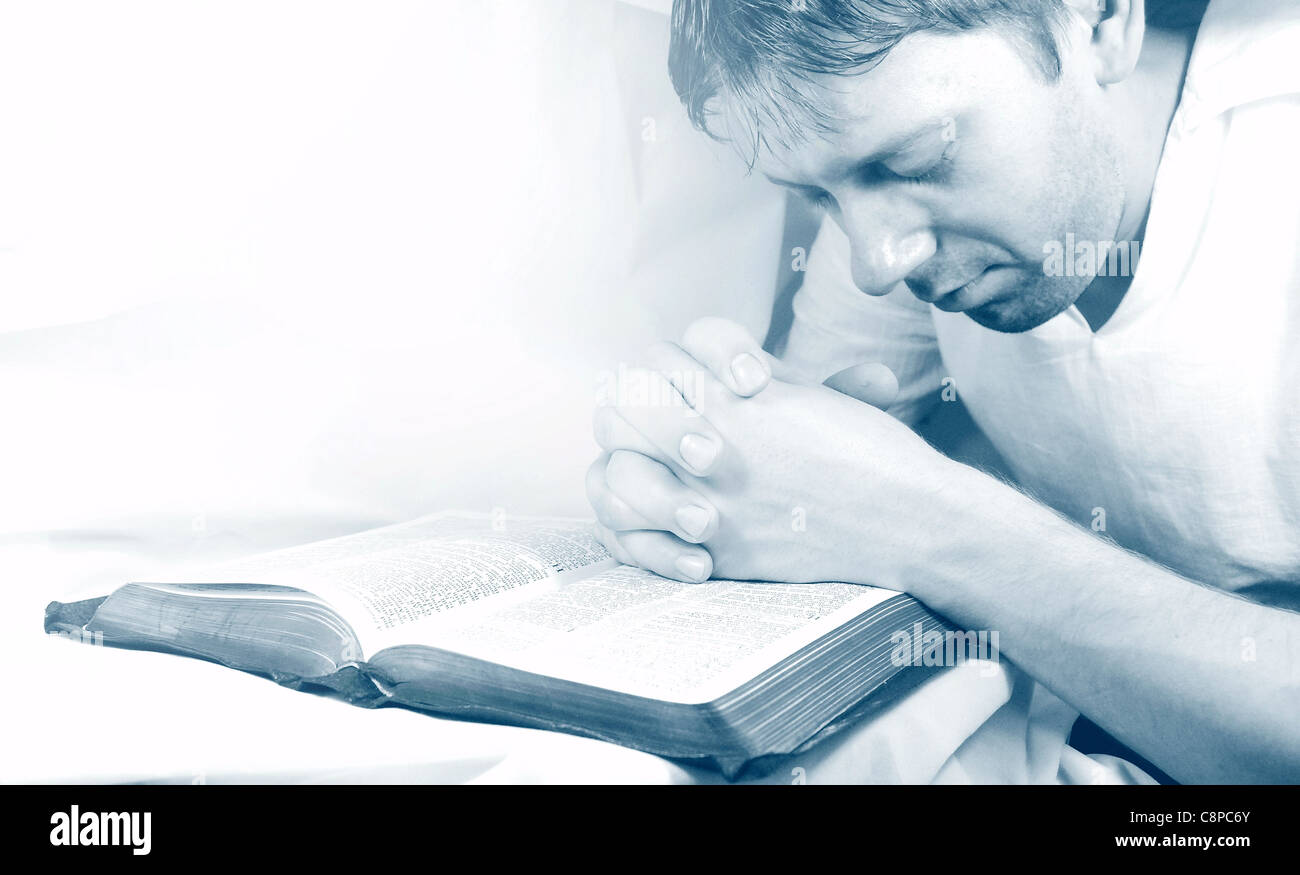 Man praying with bible Stock Photo - Alamy
