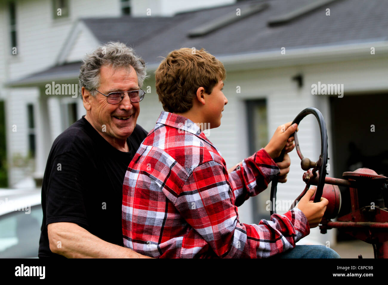 Grandfather teaching his Grandson how to drive a stick shift on a ...