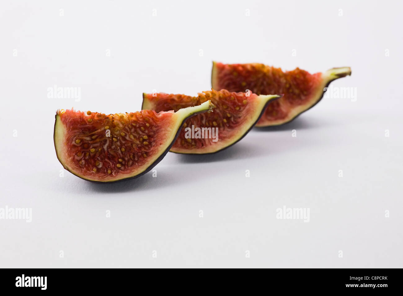Ficus carica. Three black Bursa fig segments on a white background ...
