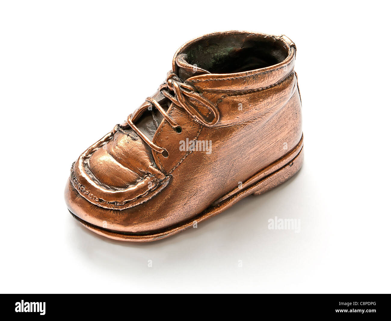 Single bronze baby shoe on white background Stock Photo - Alamy