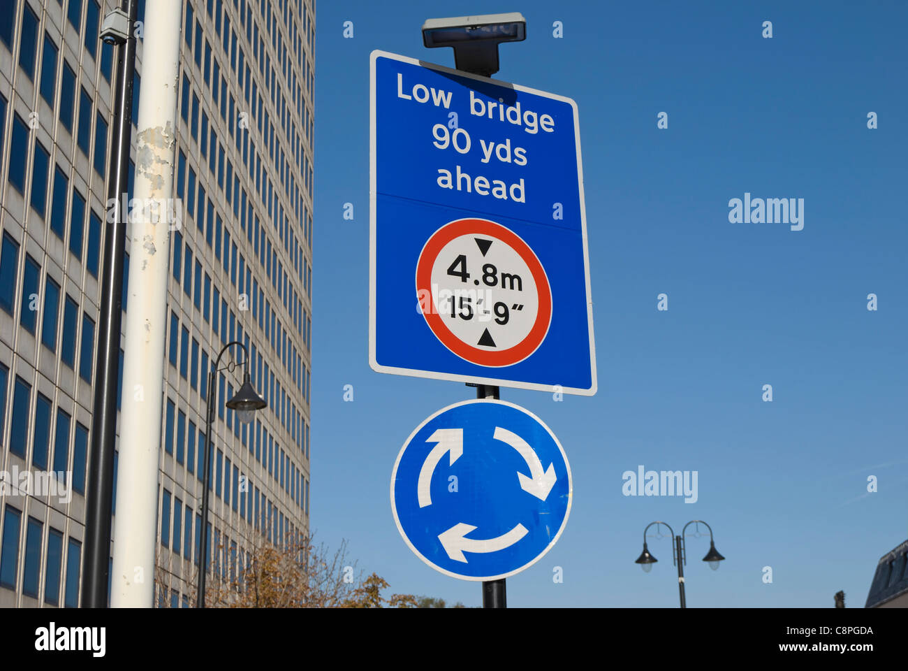 british road signs indicating a low bridge and a roundabout ahead, in ...