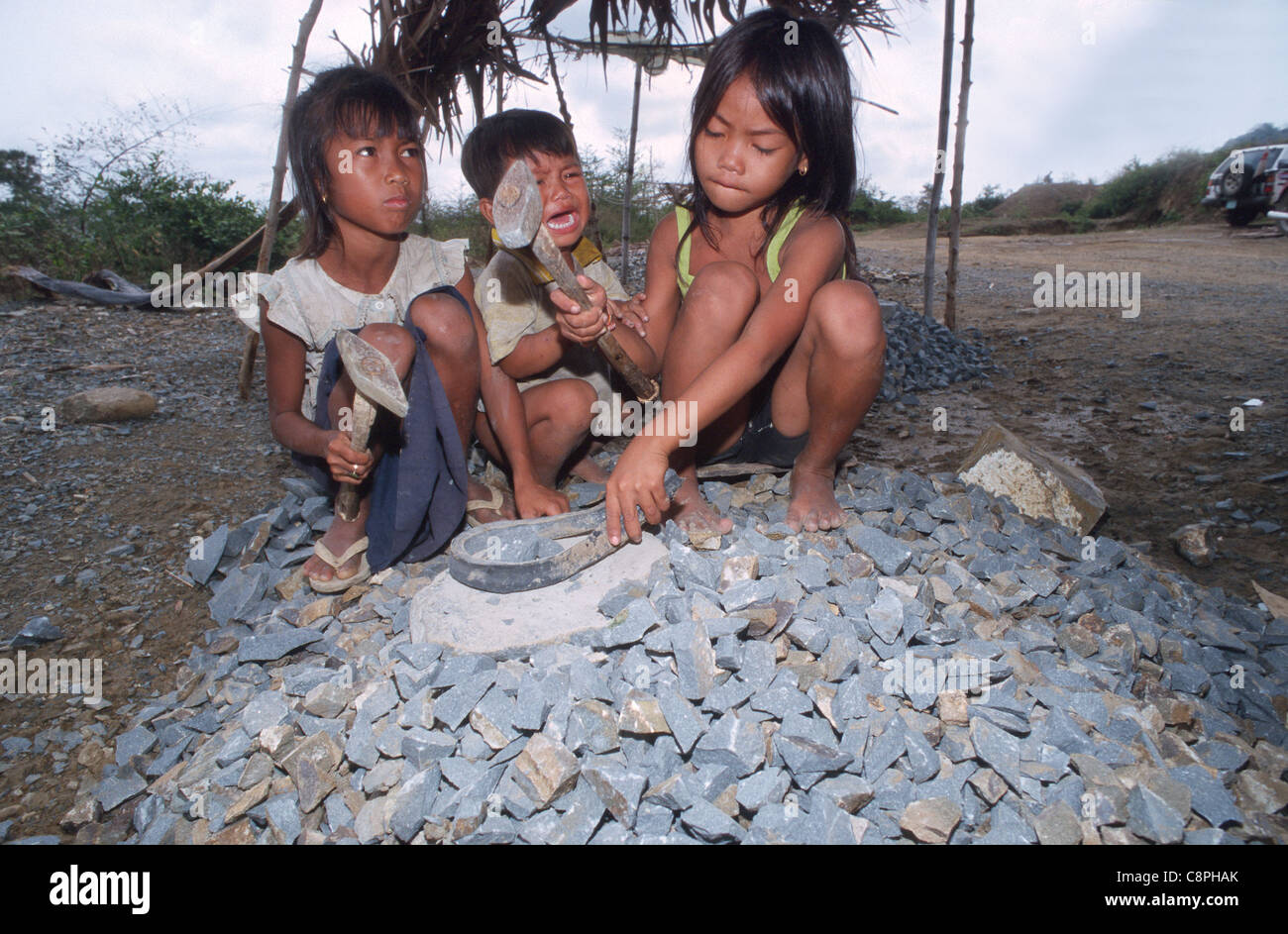 Child labourers work in a quarry breaking stones to build roads. Takeo ...