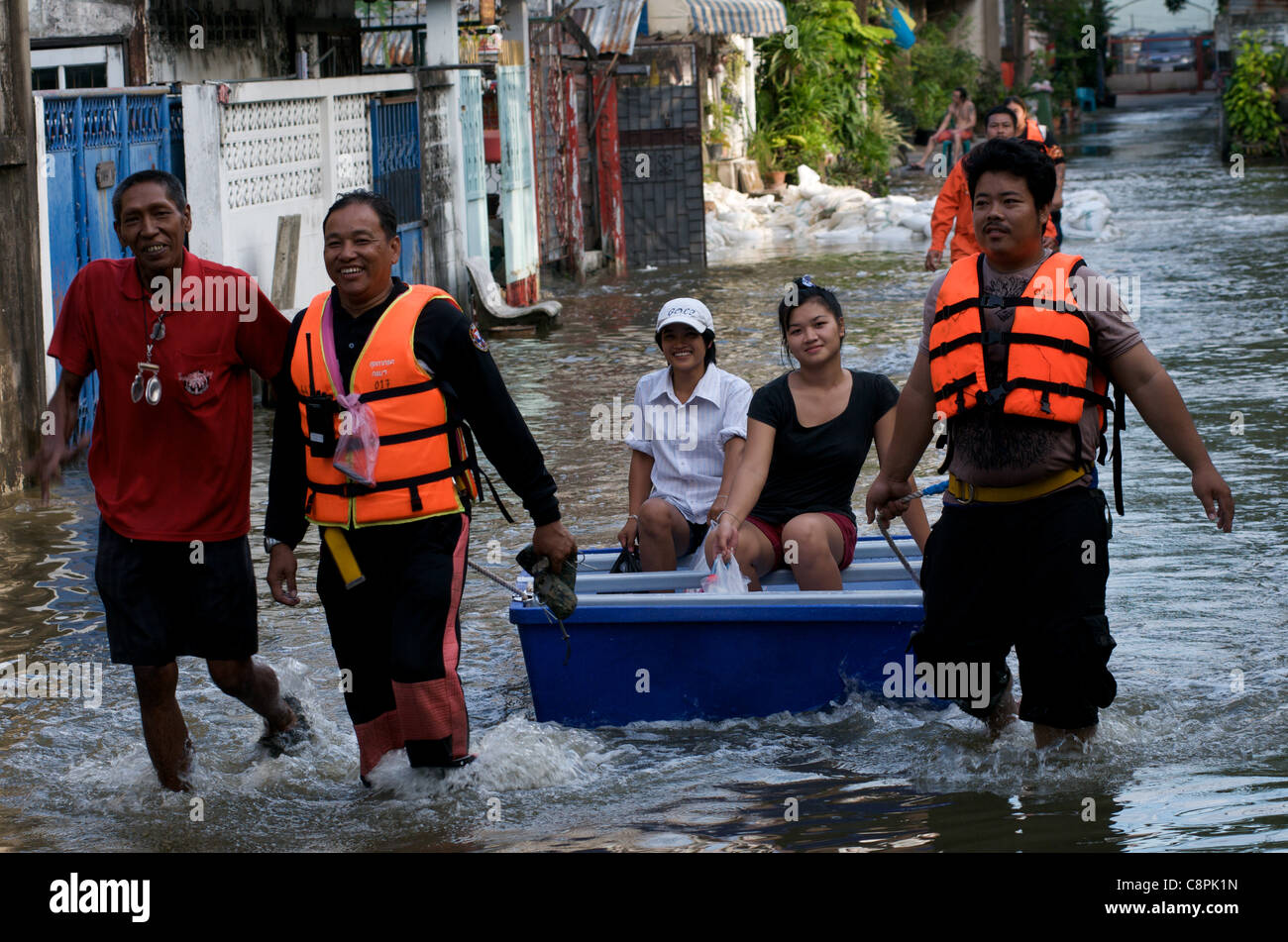 Thai women are pulled through flood waters in a boat due to a breach in ...