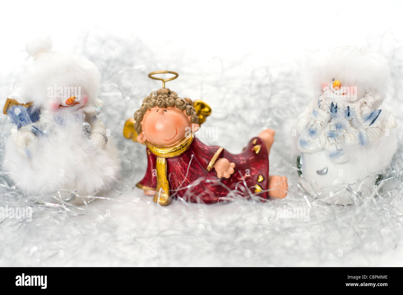 Decorative Christmas snowmen and an angel ornament on a white ...