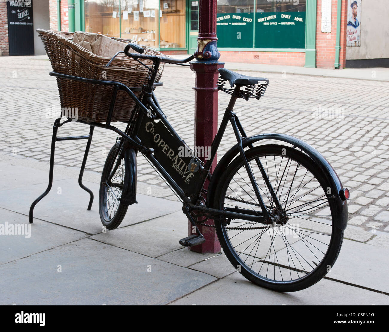 Old bicycle with Co operative logo chained to post Stock Photo - Alamy