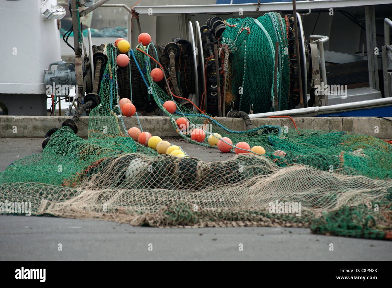 Fishermen are mending nets in the fishing harbour Stock Photo - Alamy
