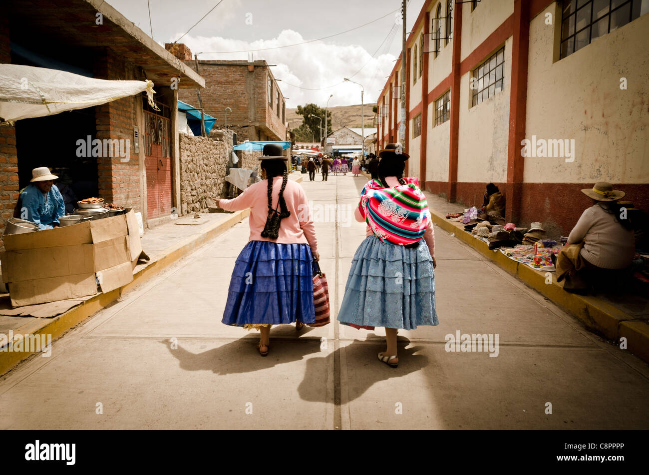 Women wearing traditional Peruvian costume walking in street Chucuito ...