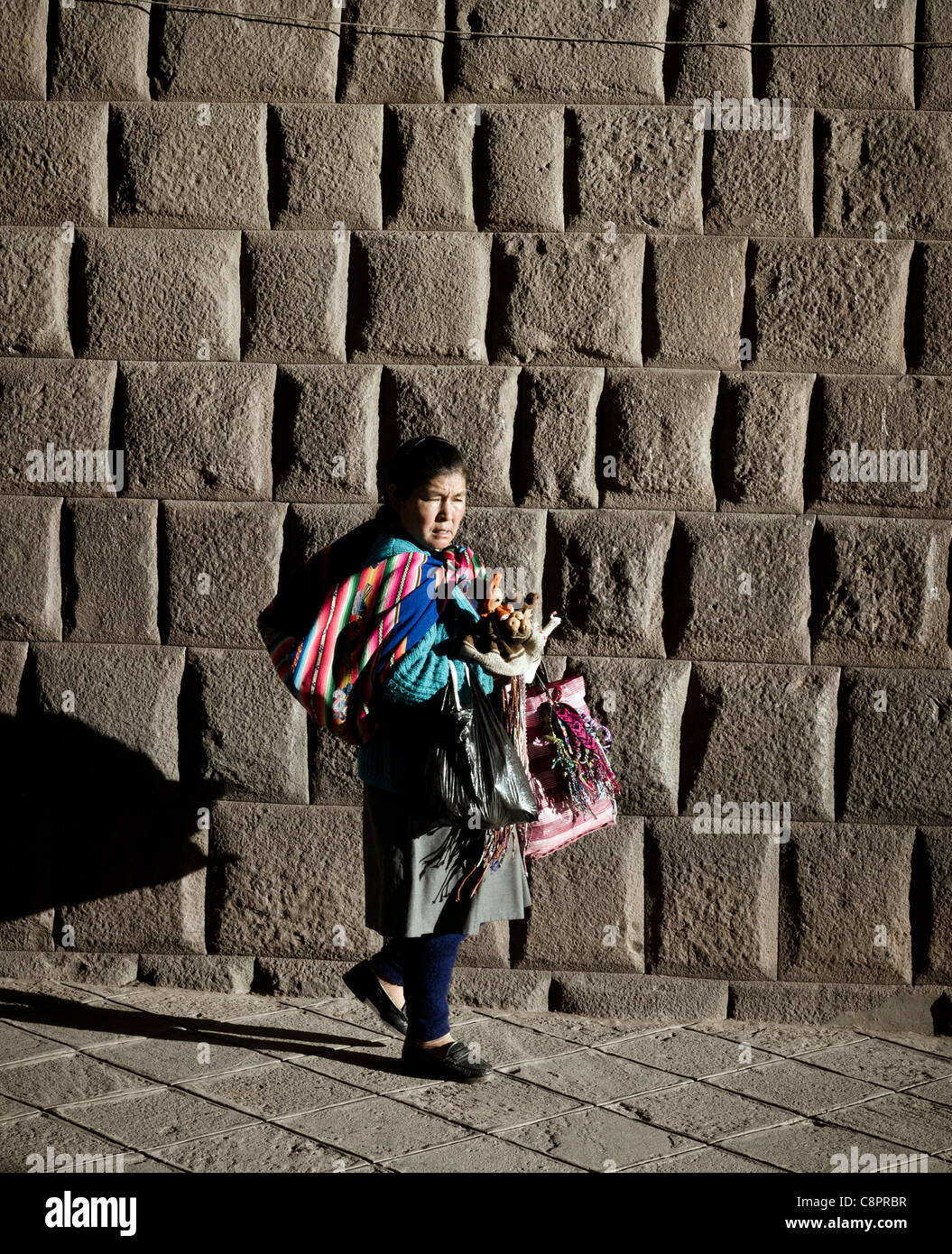 Peruvian woman walking by Inca wall Cusco Peru Stock Photo - Alamy
