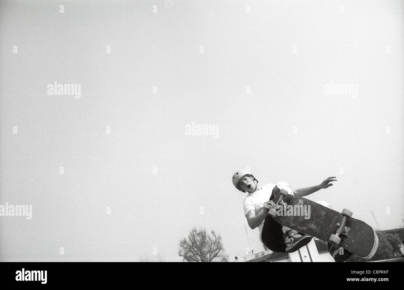 A skateboarder competes in a vert skateboarding contest on a half-pipe ...