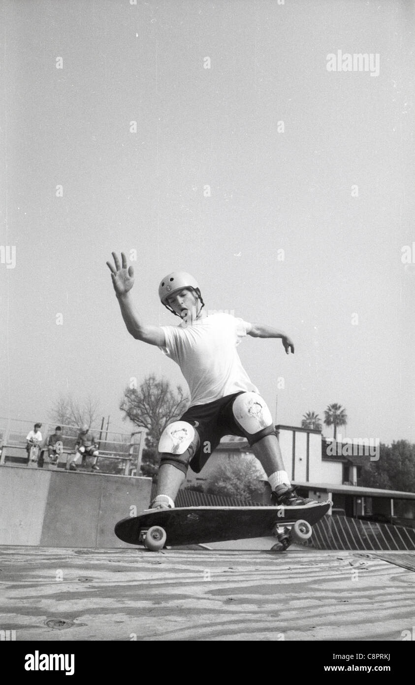 A skateboarder competes in a vert skateboarding contest on a half-pipe ...