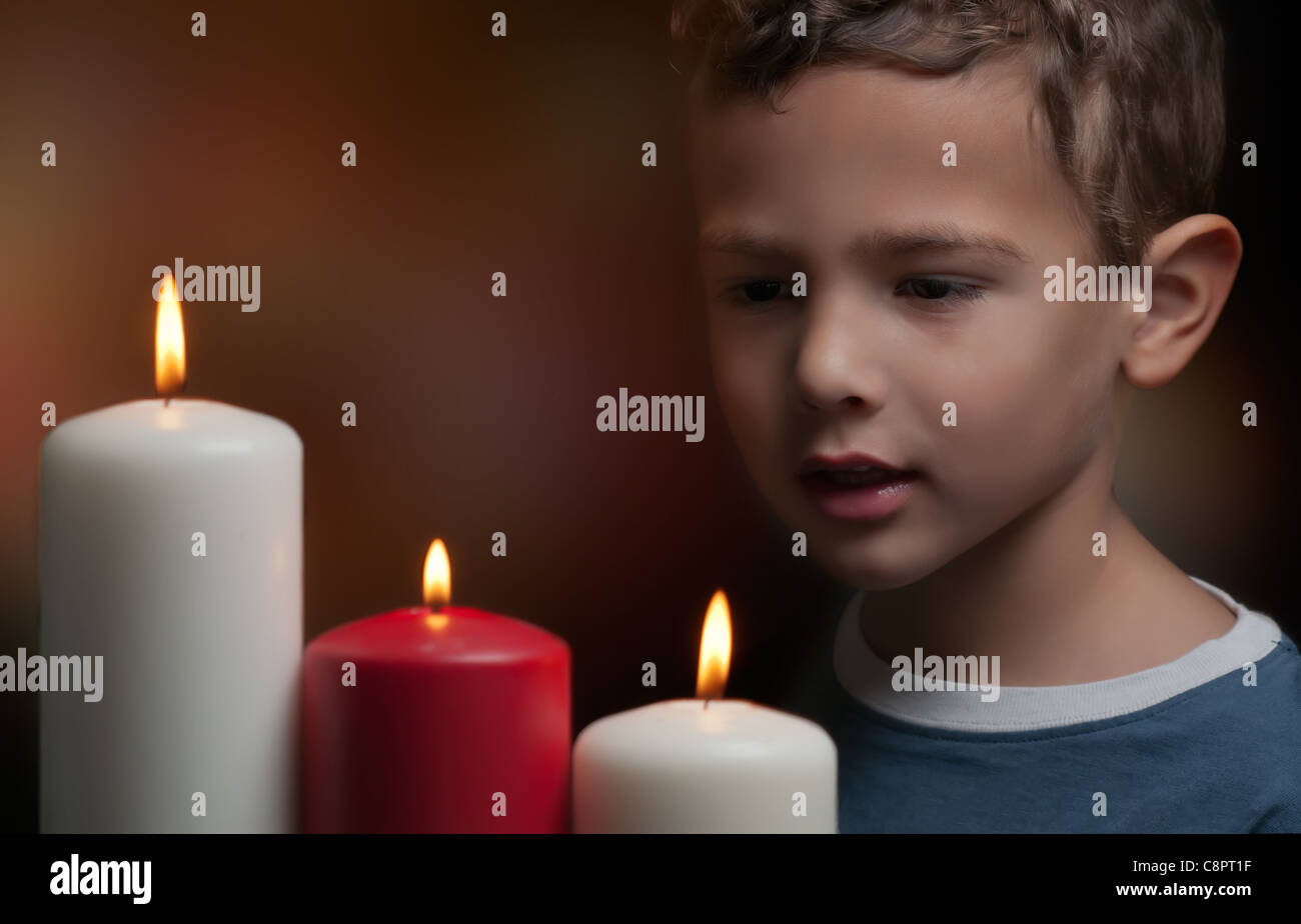 A child watching three candles burning Stock Photo - Alamy