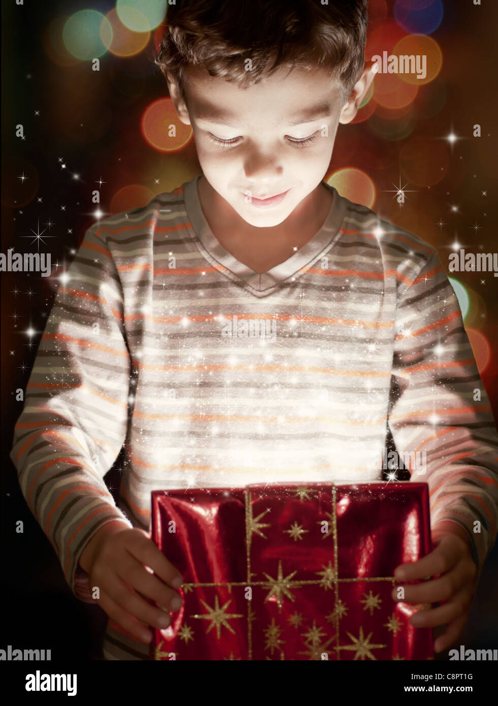 A surprised child opening and looking inside a magic gift Stock Photo ...