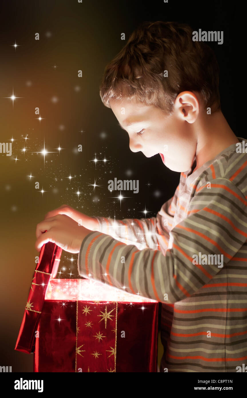 A surprised child opening and looking inside a magic gift Stock Photo ...