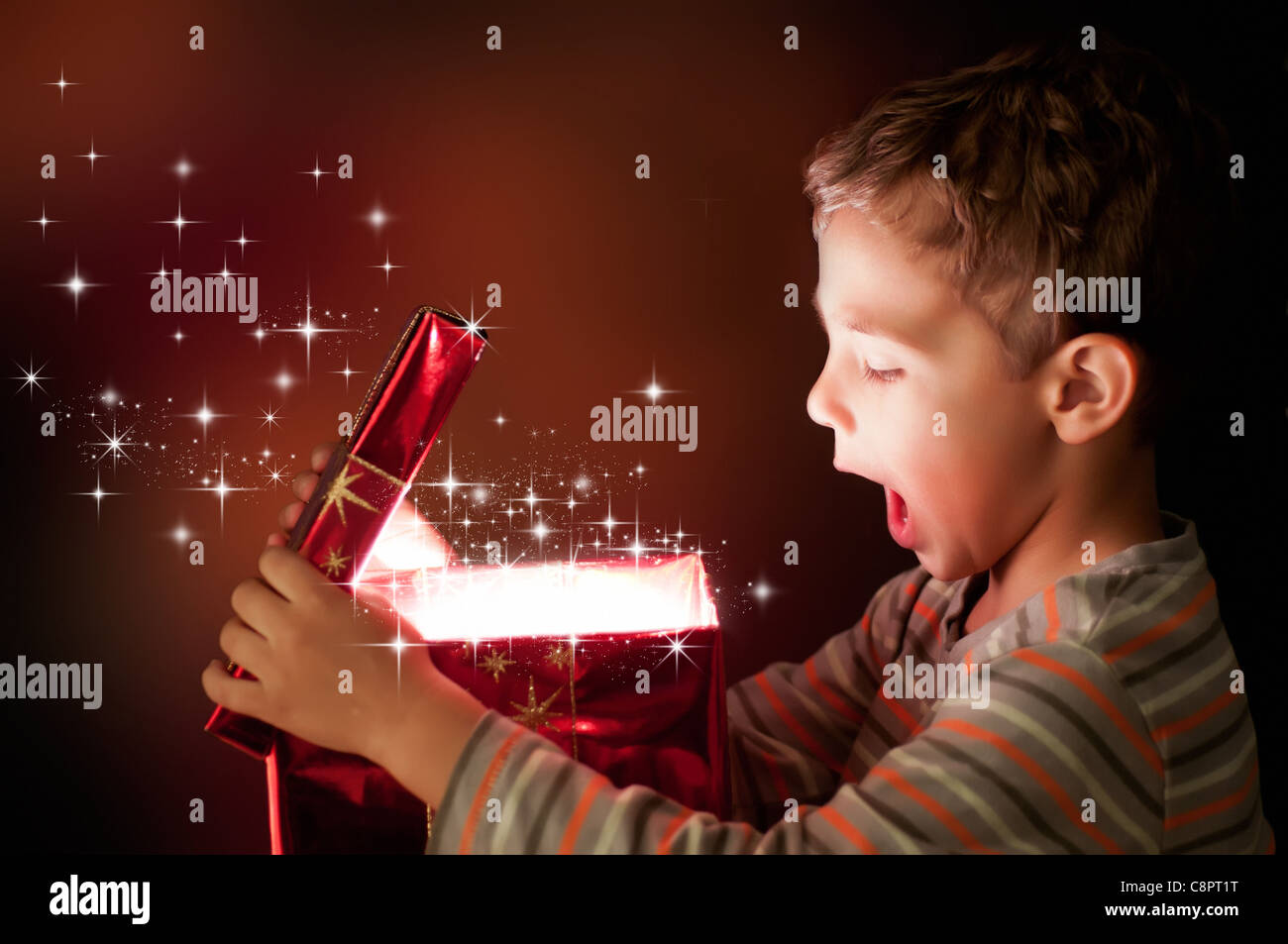 A surprised child opening and looking inside a magic gift Stock Photo ...