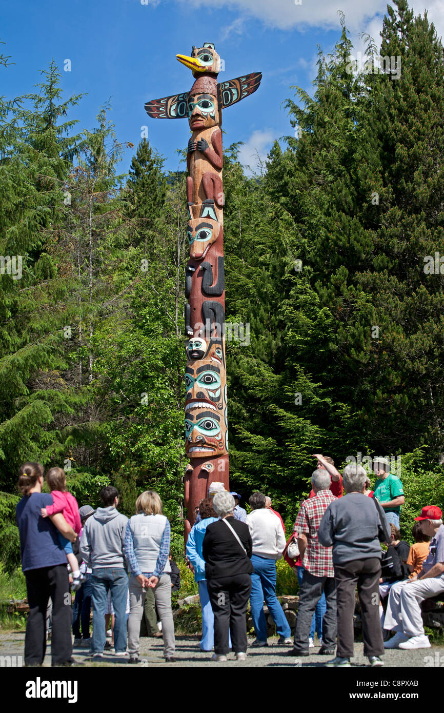 Tourists contemplating a totem pole. Saxman Totem Park. Ketchikan ...