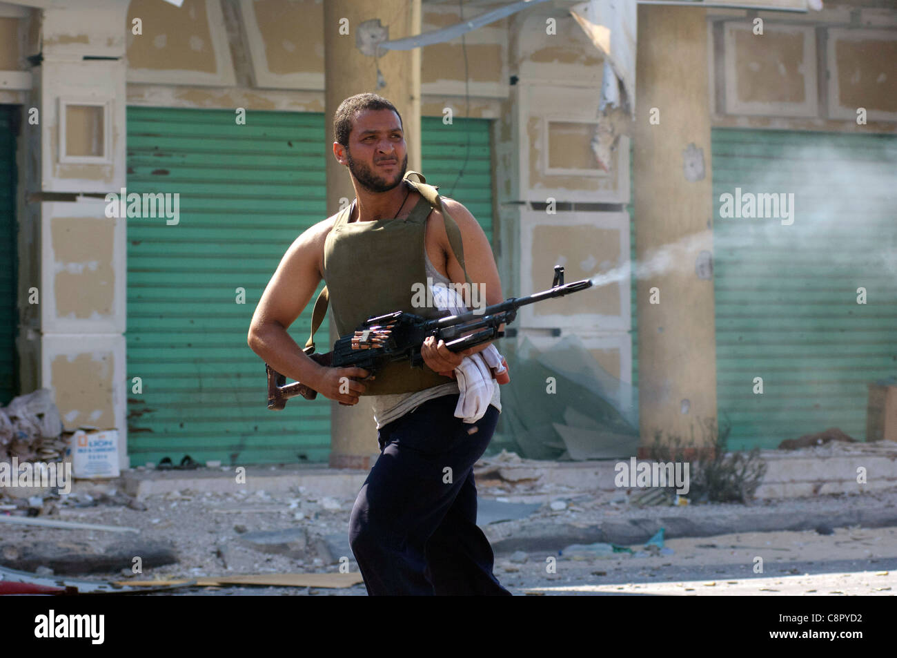 Rebel fighter battles snipers in the square occupied by Gaddafi forces ...