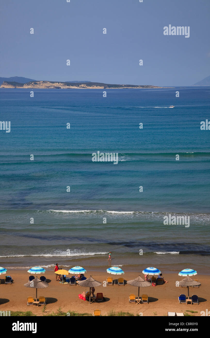Agios Stephanos beach with sunbeds and tourists, view across the ...