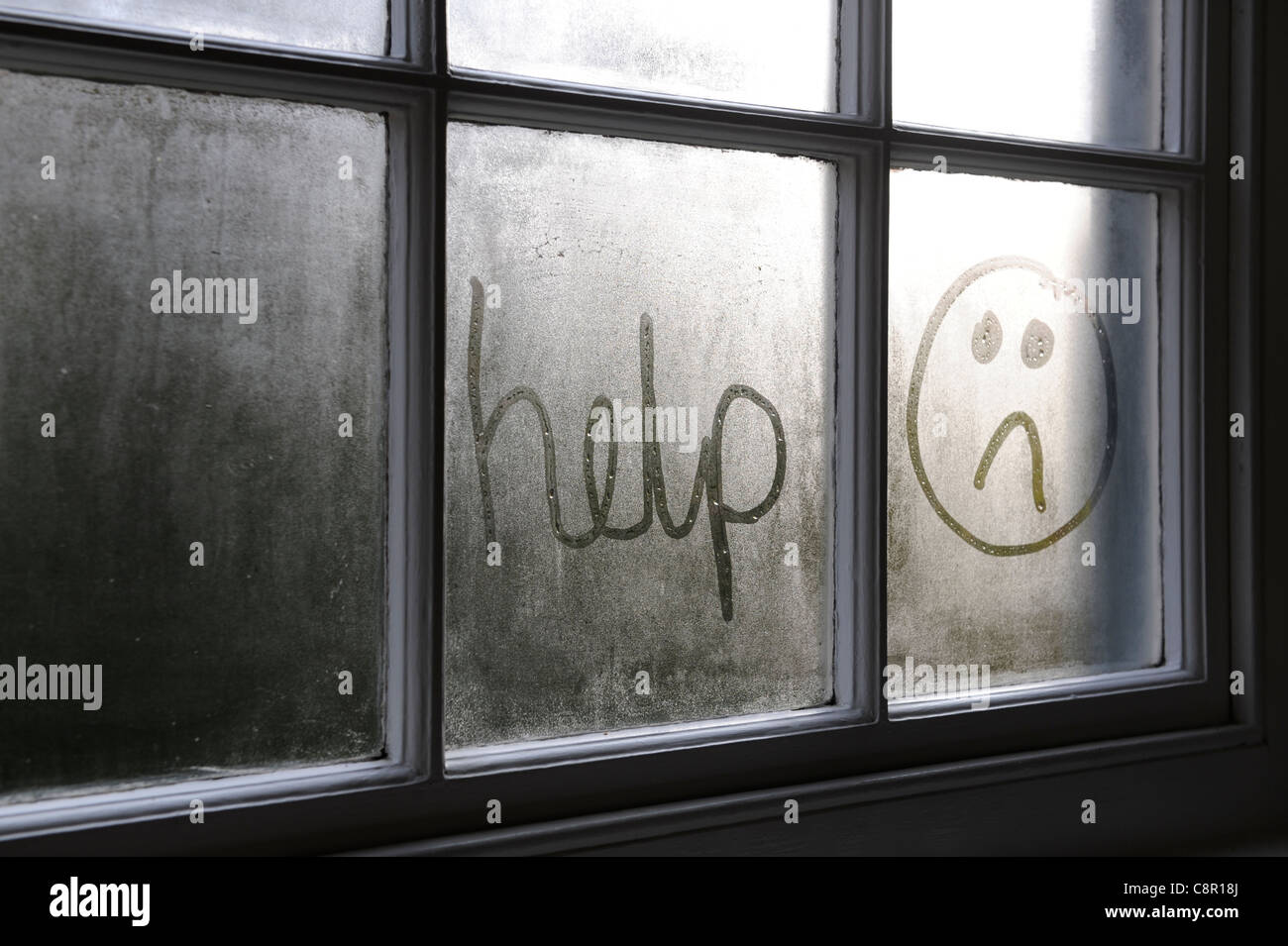 HELP and a sad face written in the condensation of a window Stock Photo ...