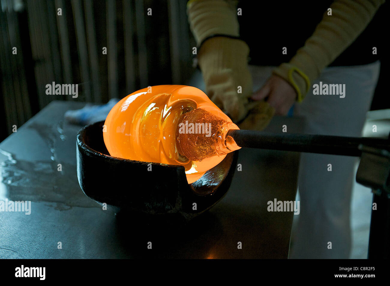 A piece of molten glass is worked in the hot shop of Gillies Jones ...