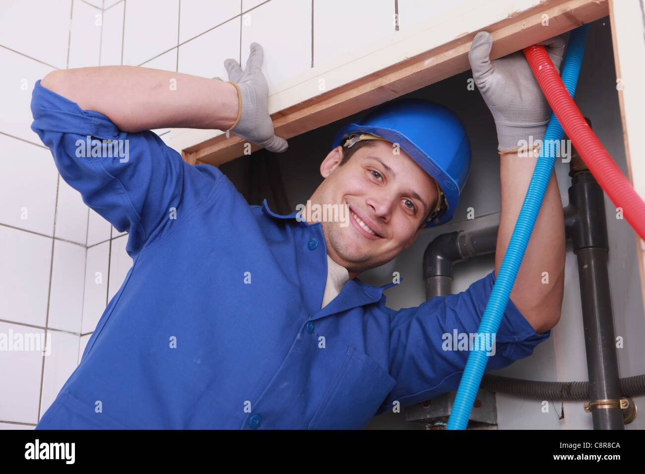 Man fixing plumbing in bathroom Stock Photo - Alamy
