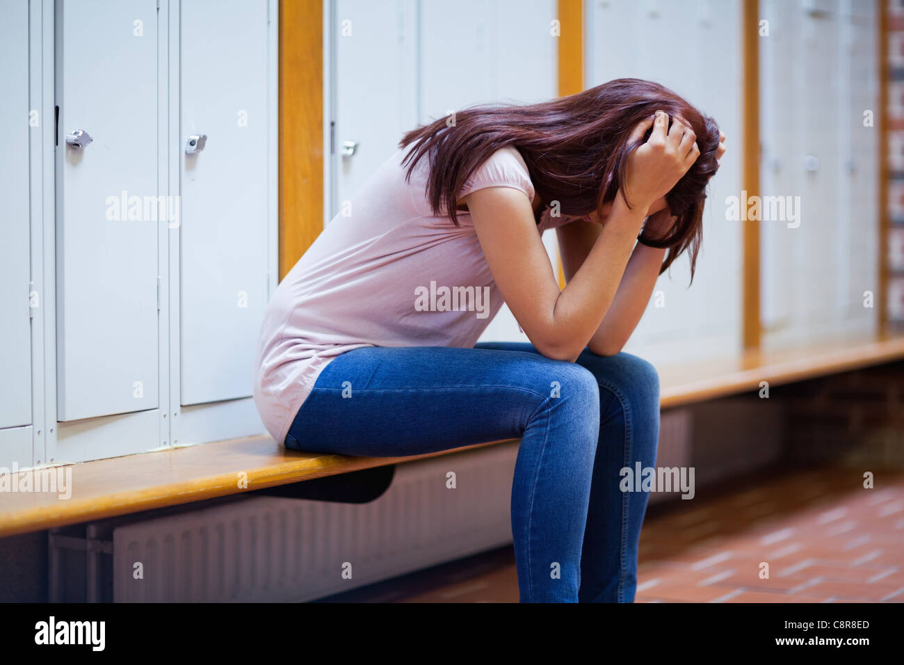 Sad student sitting on a bench Stock Photo - Alamy