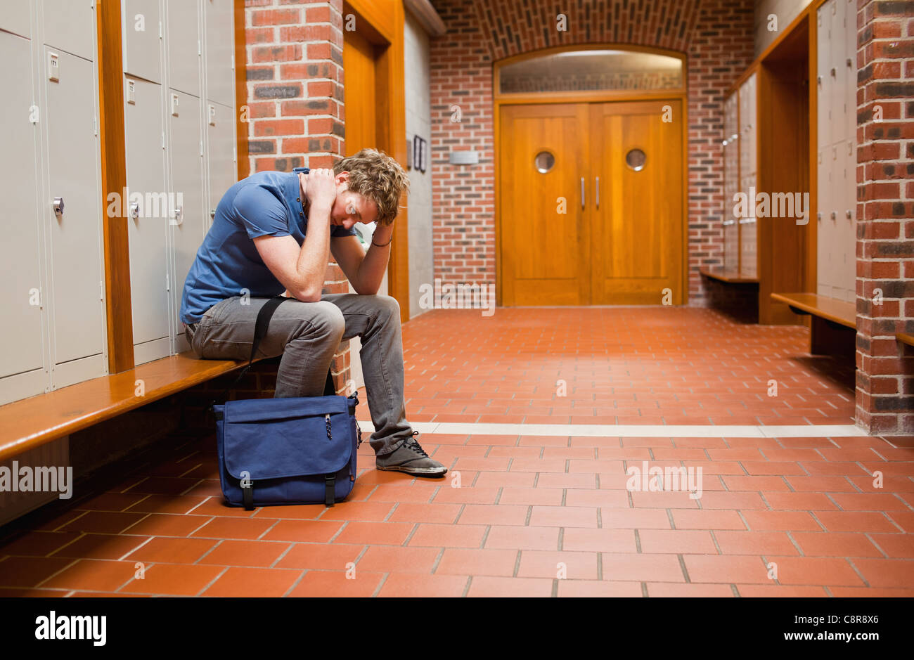 Sad student sitting on a bench Stock Photo - Alamy