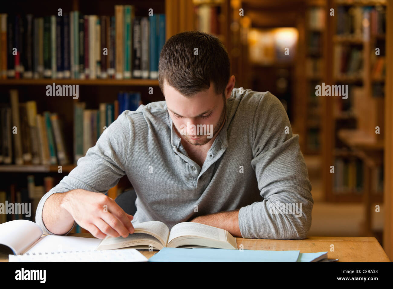 Male student researching with a book Stock Photo - Alamy