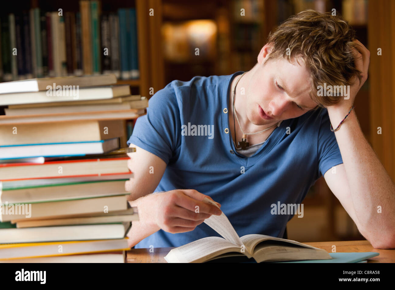 Tired man reading a book Stock Photo - Alamy