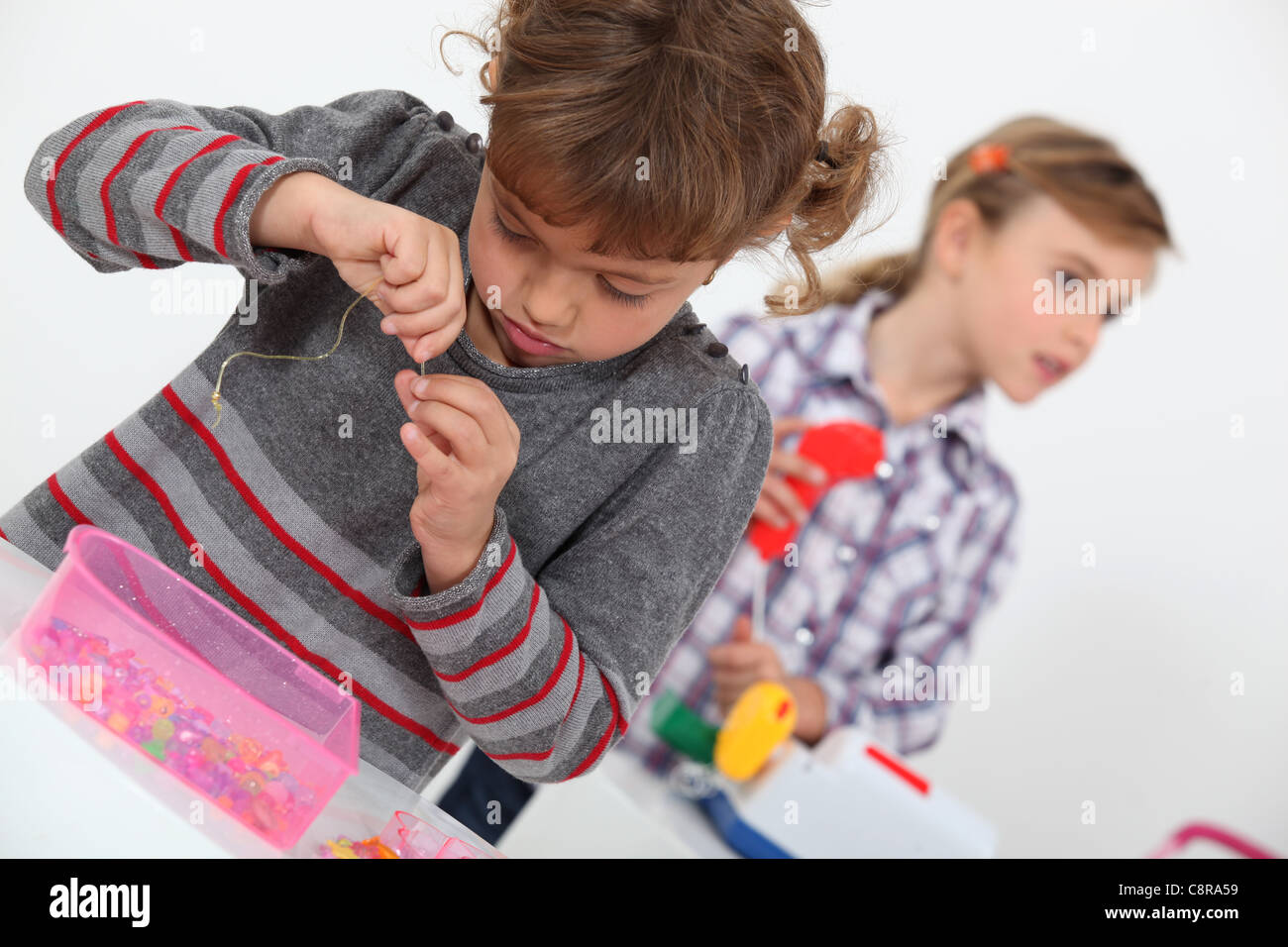 Young girl putting a thread through the eye of a needle Stock Photo - Alamy