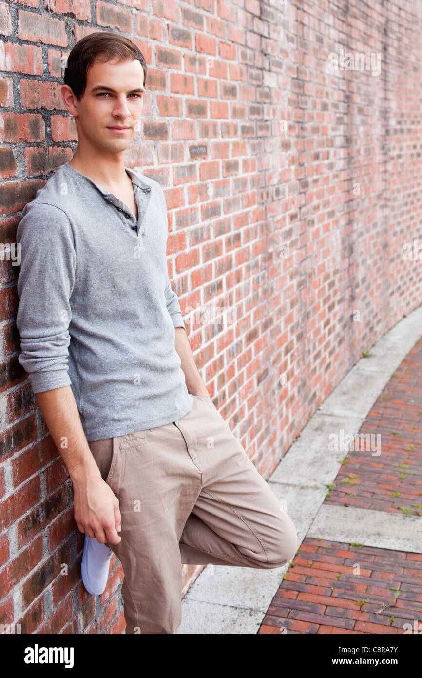 Portrait of a student leaning on a wall Stock Photo - Alamy