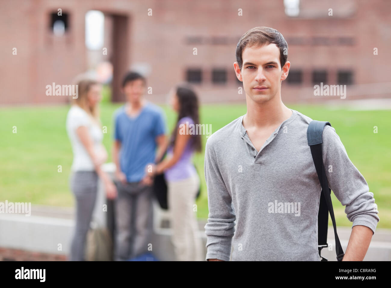 Male student posing while his classmates are talking Stock Photo - Alamy