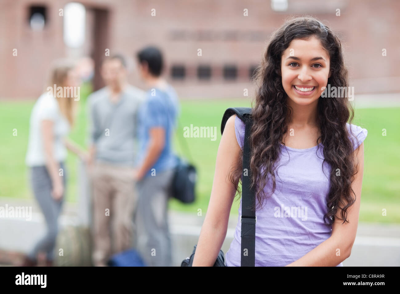 Cute student posing while his classmates are talking Stock Photo - Alamy