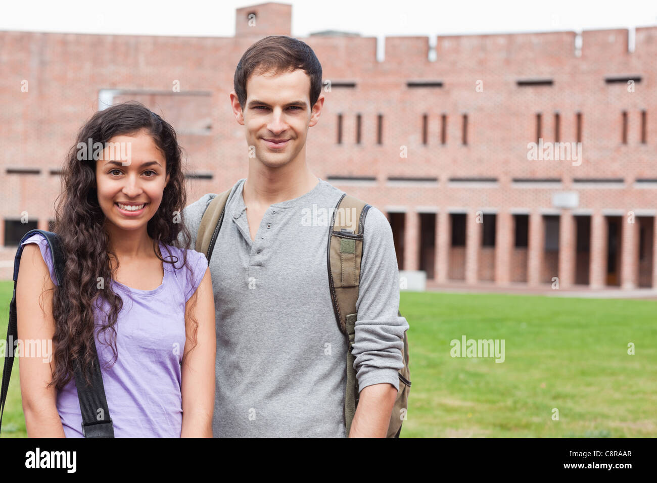 Smiling student couple posing Stock Photo - Alamy