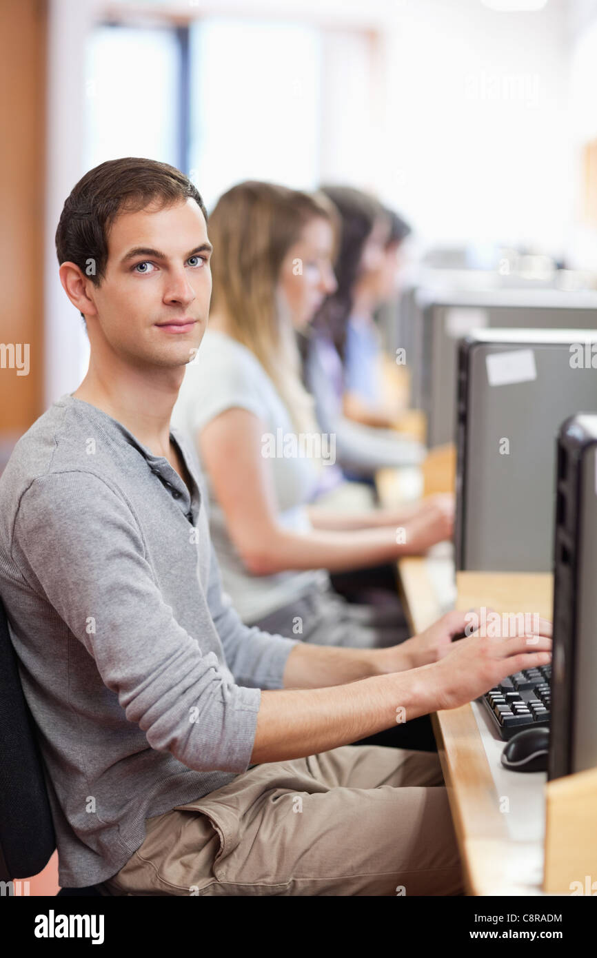 Portrait of a male student posing with a computer Stock Photo - Alamy