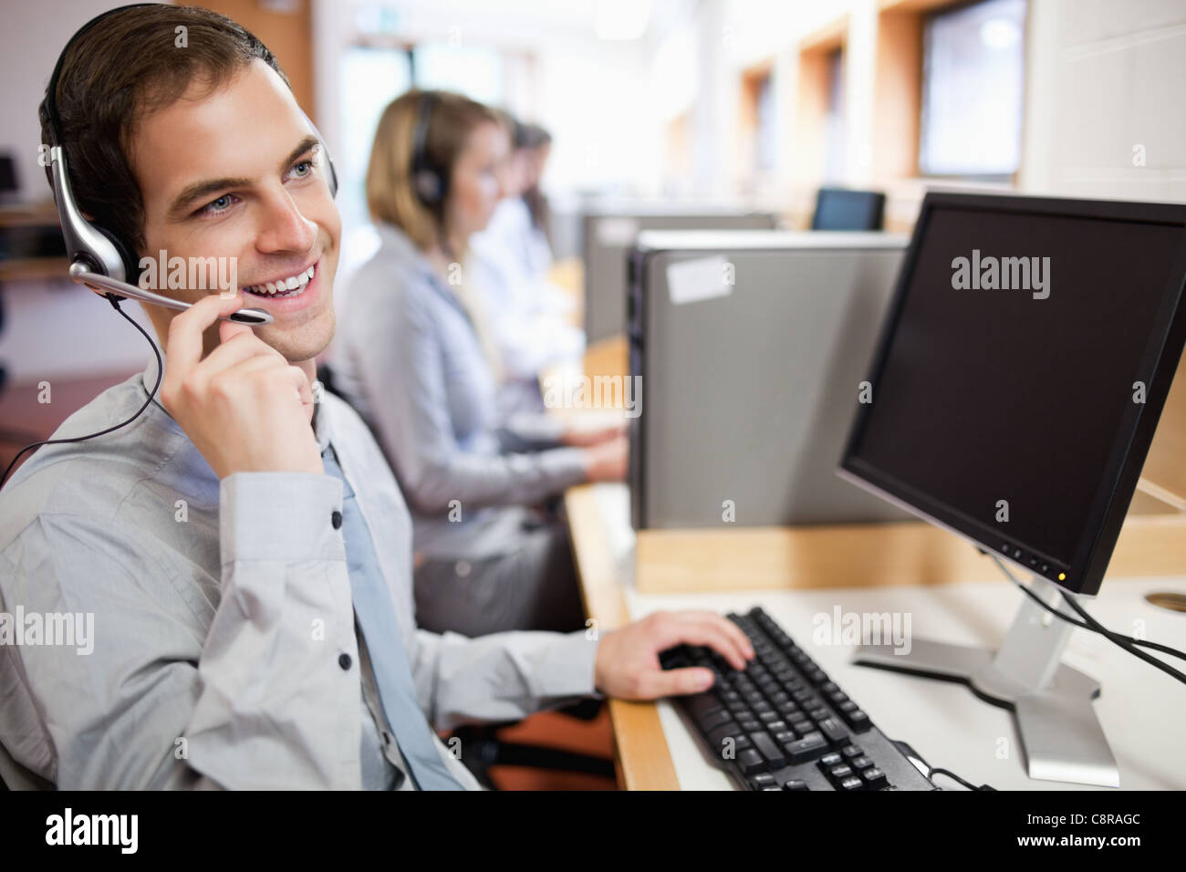 Smiling assistant using a headset Stock Photo - Alamy