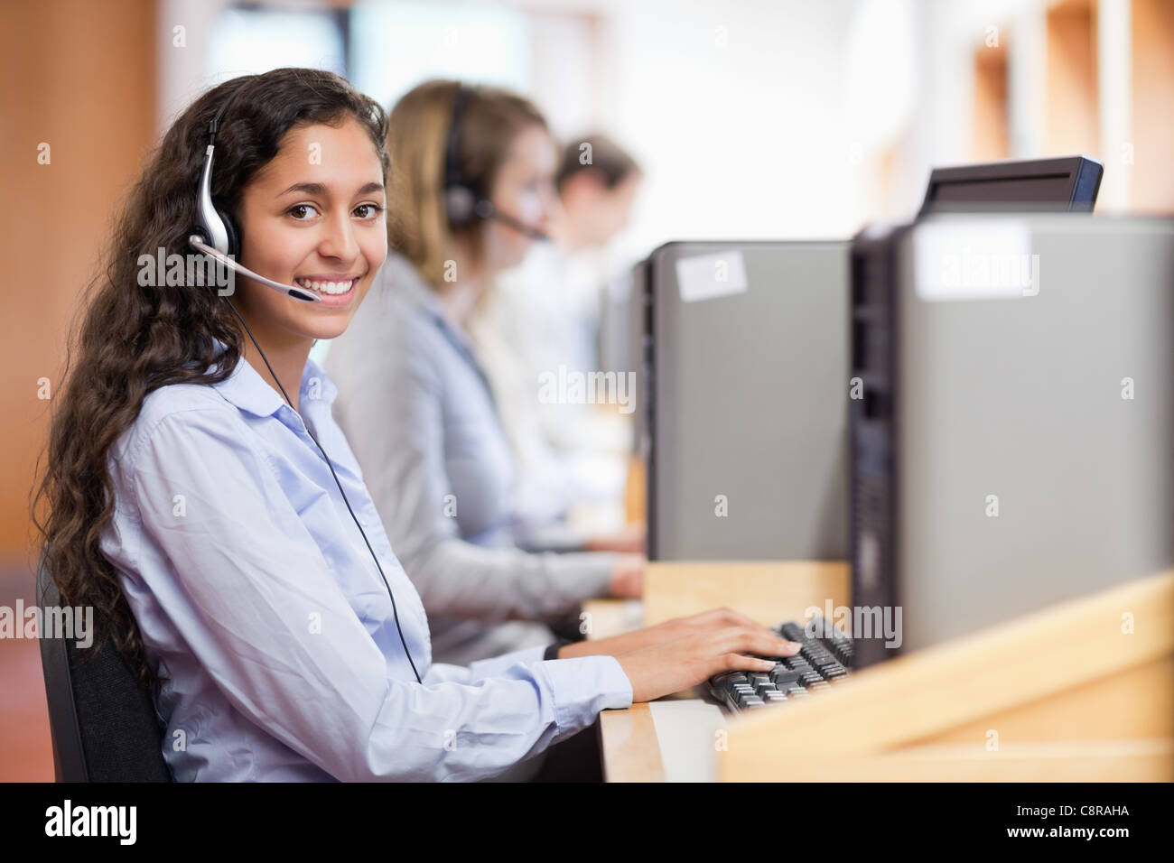 Smiling assistant working with a computer Stock Photo - Alamy