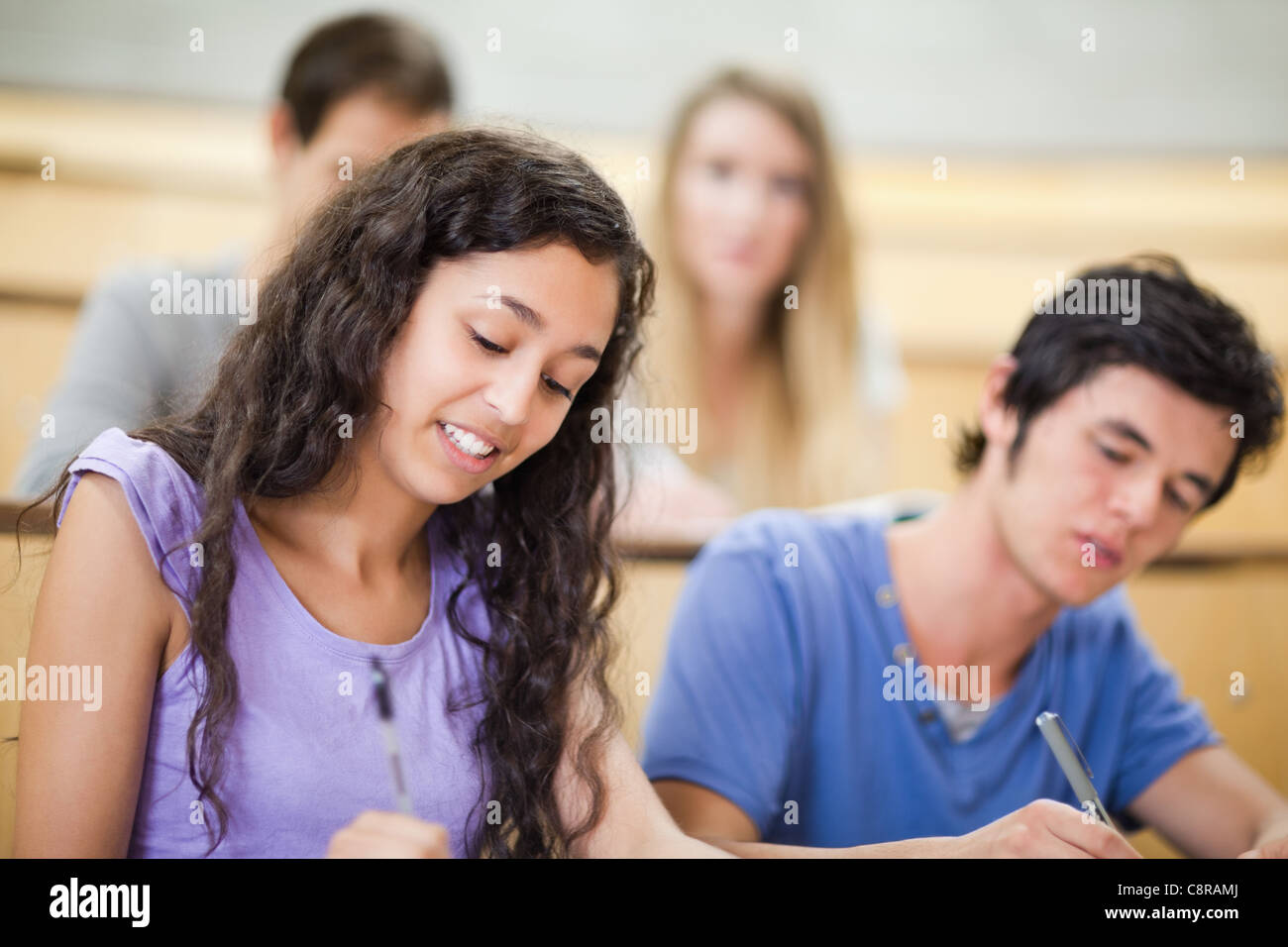 Smiling students writing Stock Photo - Alamy