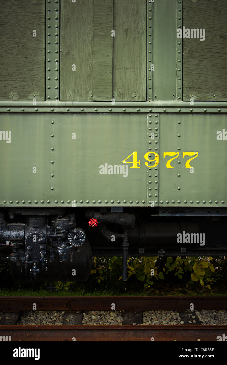 A close-up image of a section of a green, antique train-car that has ...