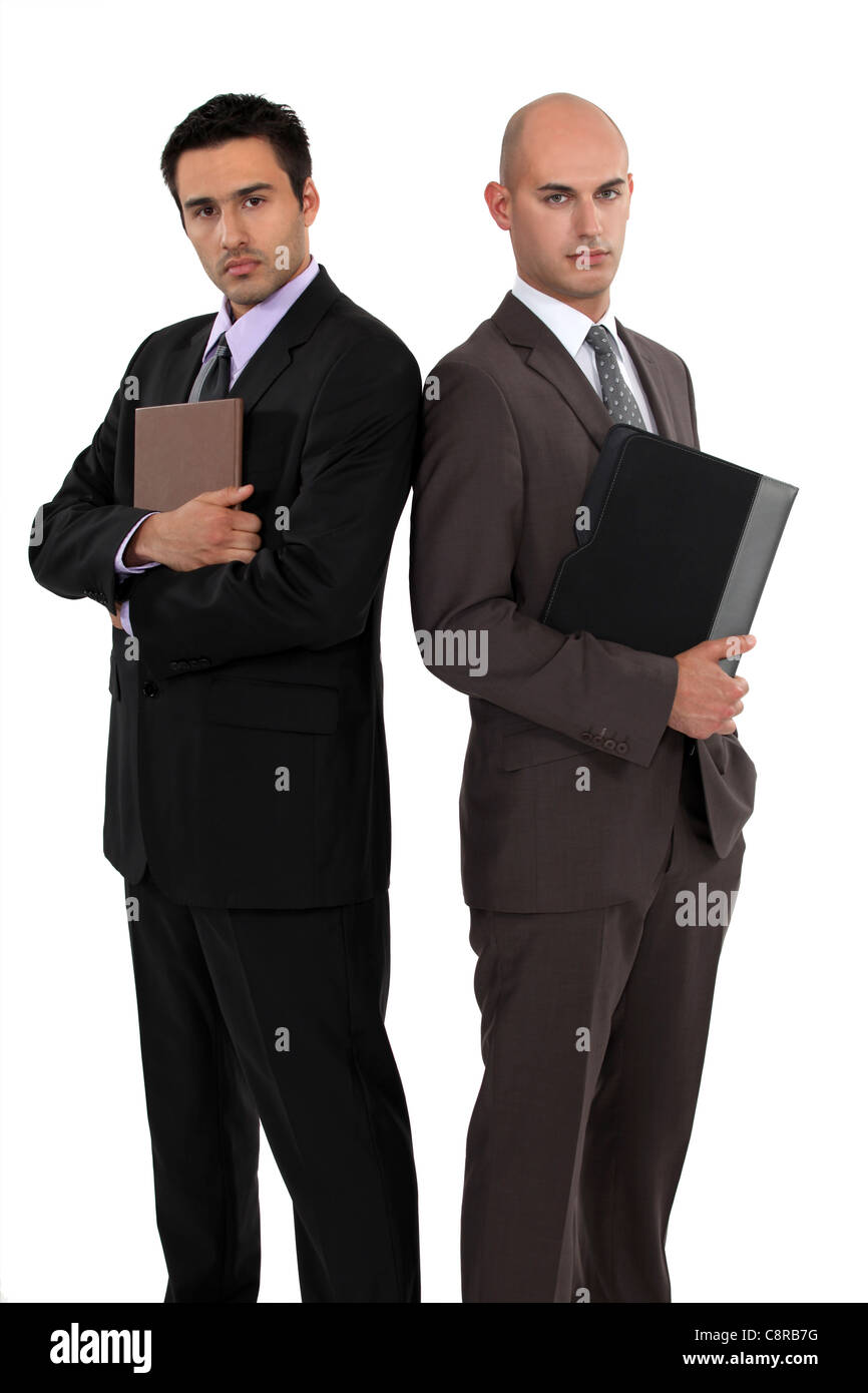 Businessmen standing back to back Stock Photo - Alamy