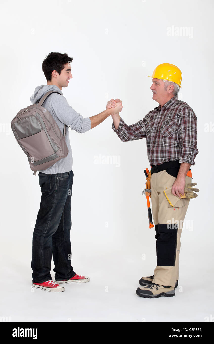 Tradesman making a pact with a young man Stock Photo - Alamy