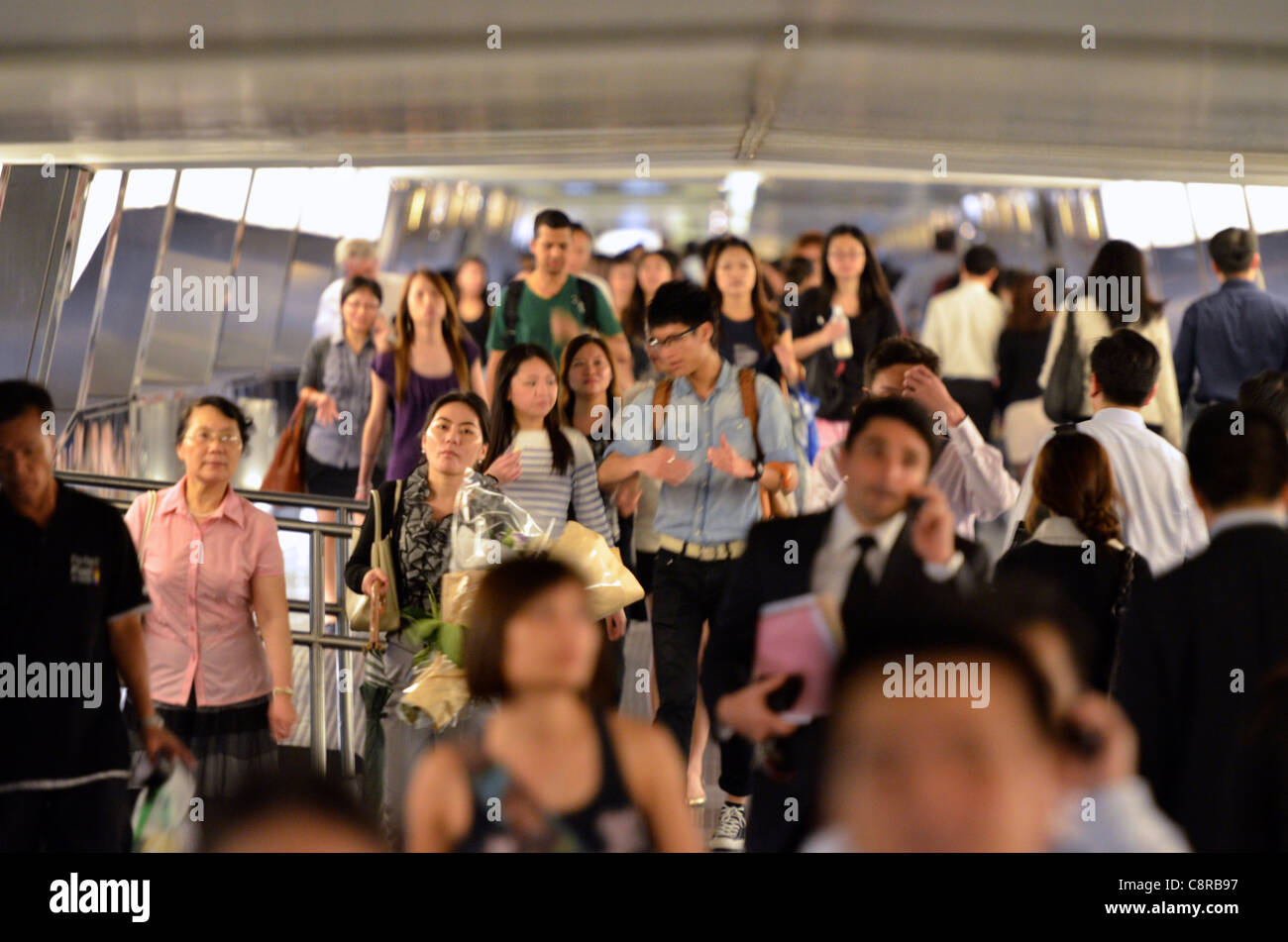 Crowds of Chinese office workers flowing along an elevated walkway in ...