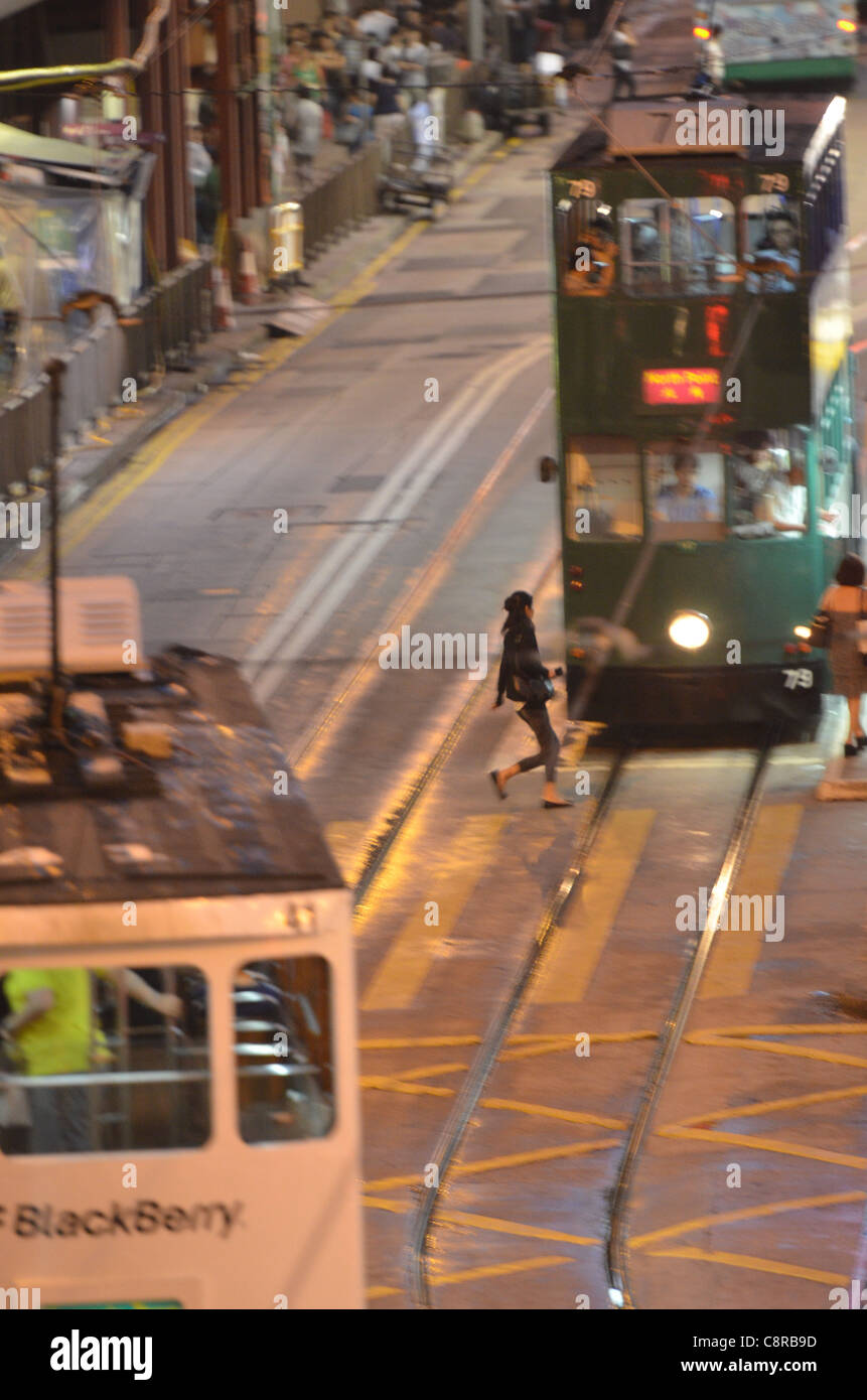 A Chinese commuter runs to catch a tram on a busy street Stock Photo ...