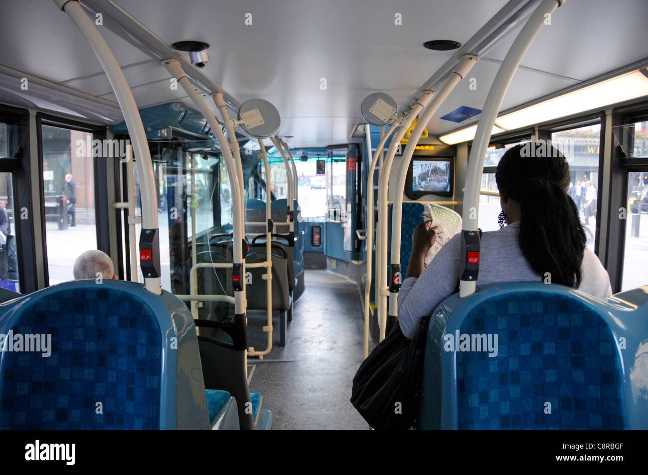 Interior of public transport single deck bus & passengers seated inside ...