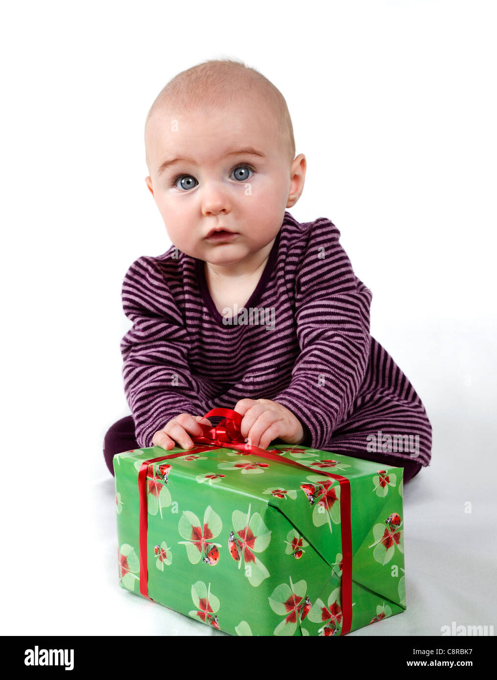 young child holding huge present and looking towards the camera Stock ...