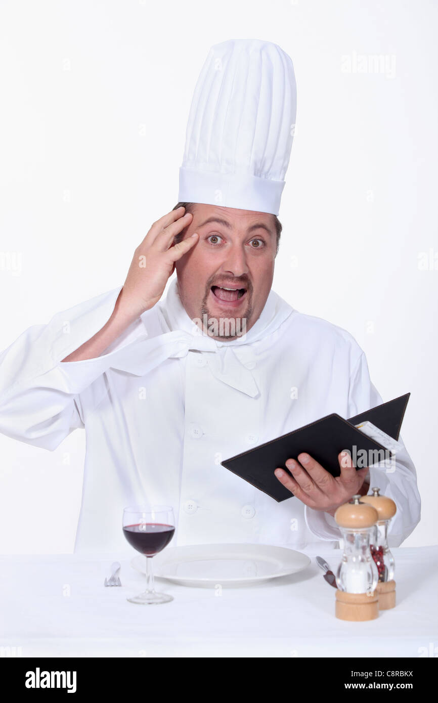 Clueless cook sitting at a table Stock Photo - Alamy